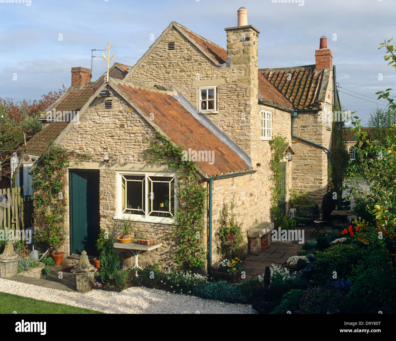 Exterior of stone country cottage with green door and unusual window ...