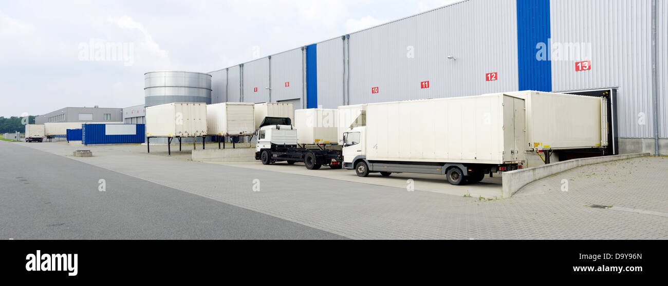 modern warehouse with containers and trucks in front Stock Photo - Alamy