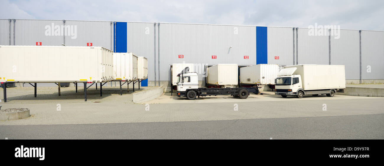 modern warehouse with containers and trucks in front Stock Photo - Alamy