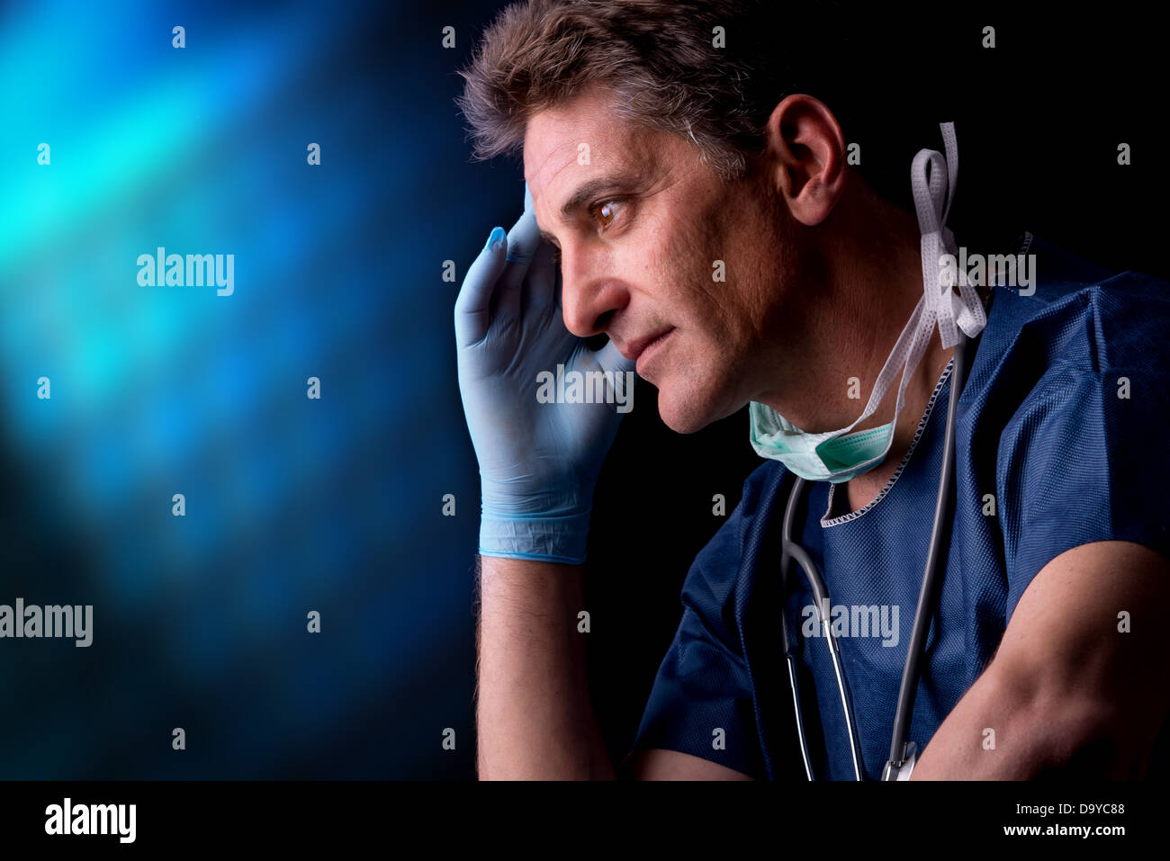 Tired doctor in uniform isolated against a black background Stock Photo ...