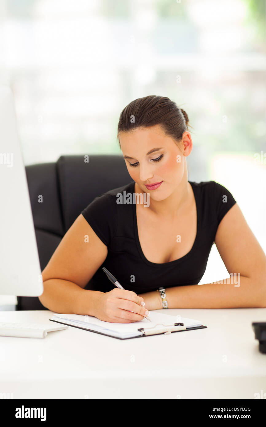 pretty business woman writing report in modern office Stock Photo - Alamy