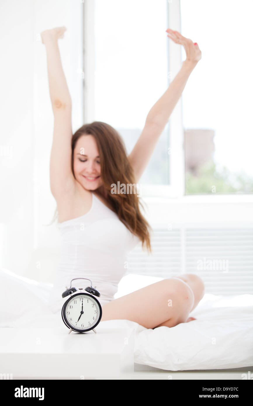 Joy cheerful happy woman waking up with a smile in bed and stretching ...