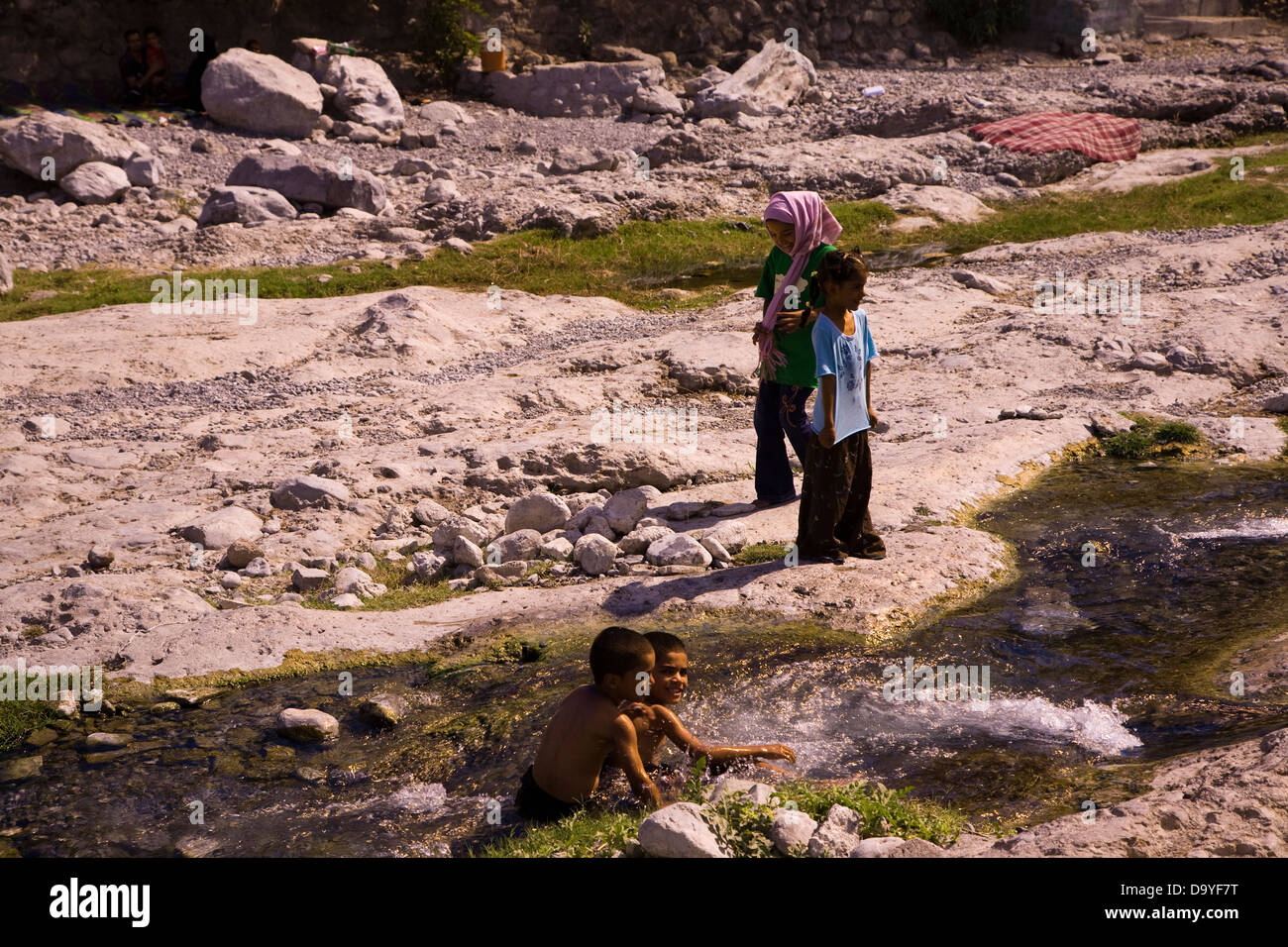 Kids play in the warm waters of Ath-Thowra springs, Nakhal, Oman Stock ...