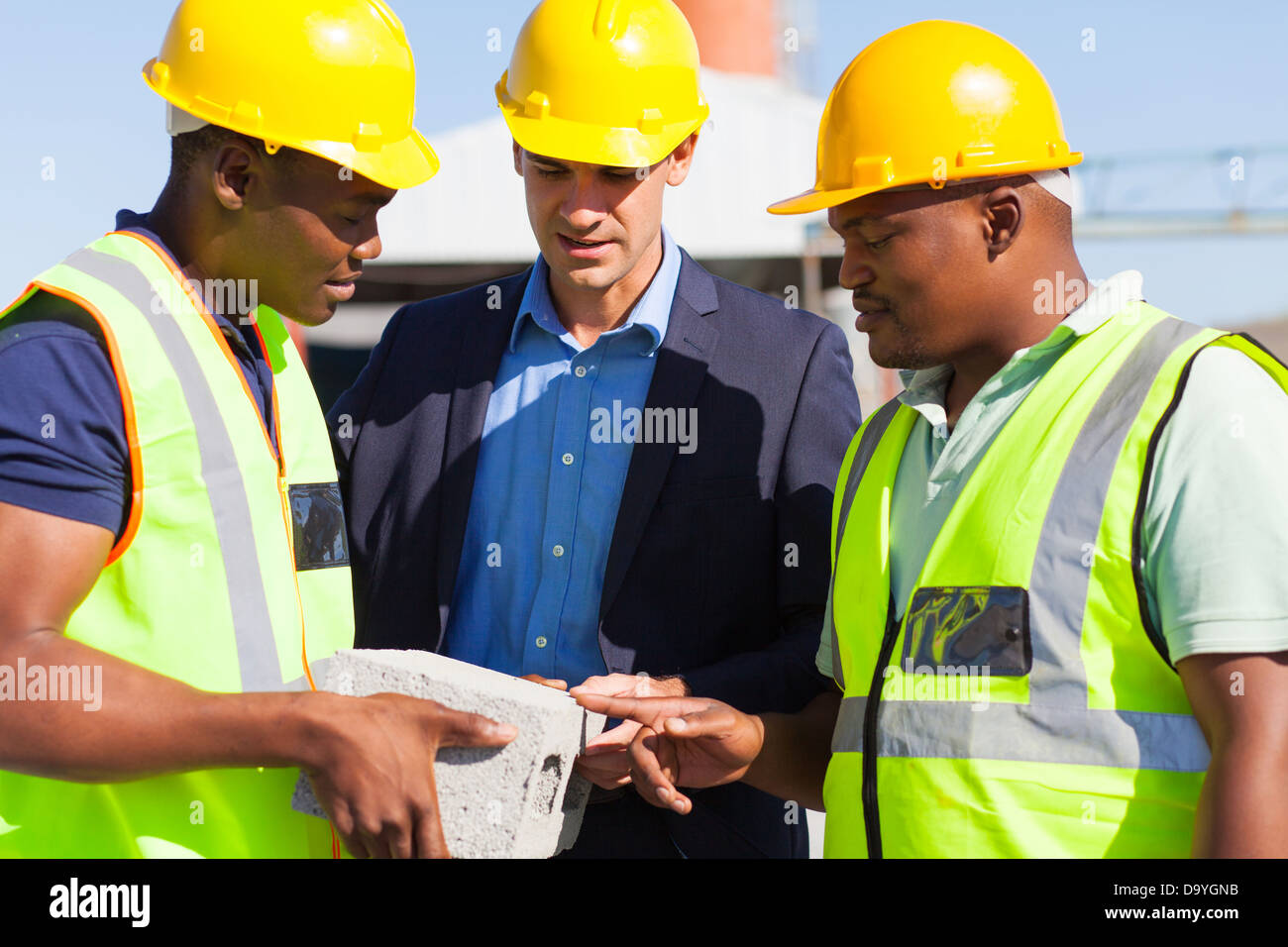 construction manager and two workers examining a brick Stock Photo - Alamy