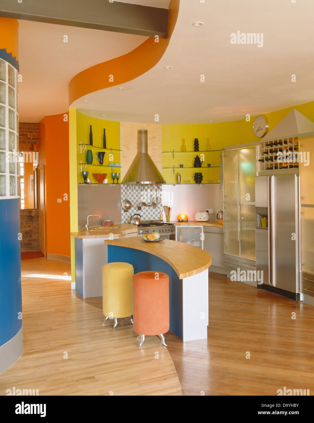Brightly colored stools at curved breakfast bar in vibrant modern ...