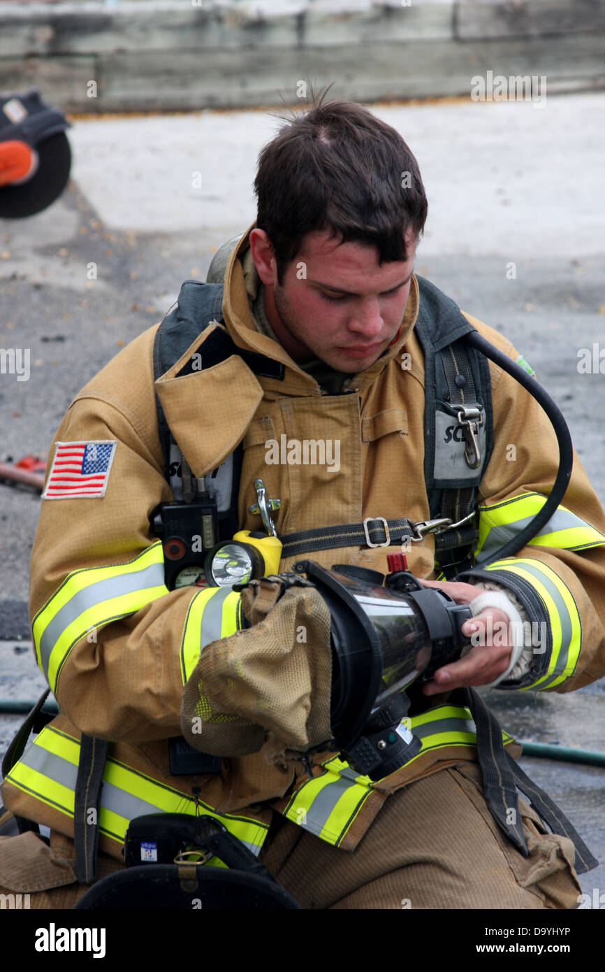 A firefighter putting on a mask Stock Photo - Alamy