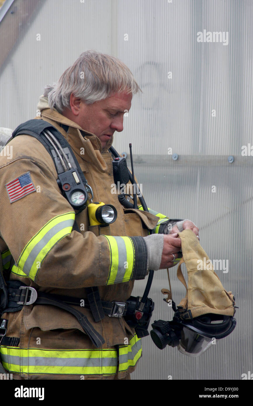 A firefighter putting on a mask Stock Photo - Alamy