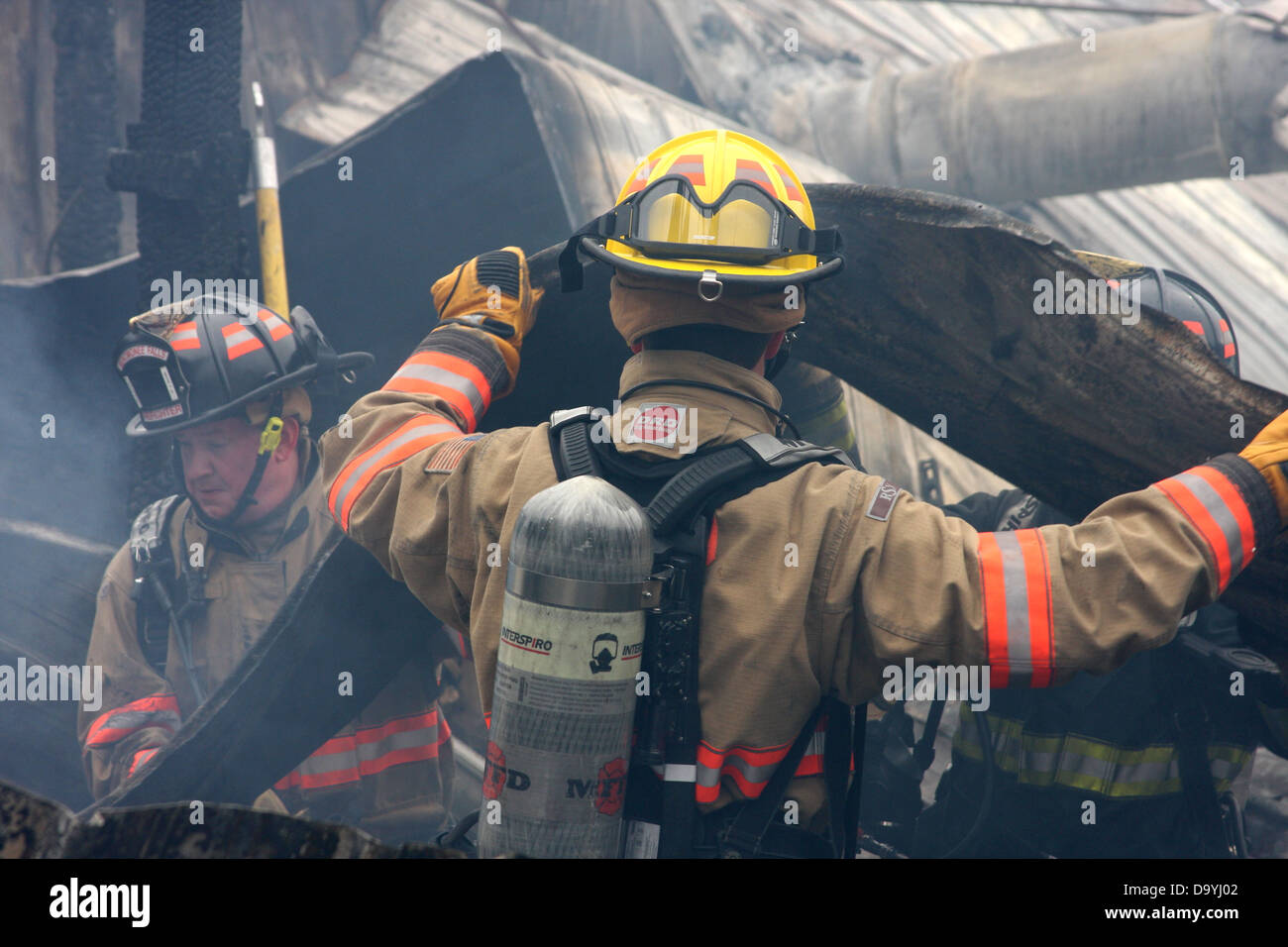 Firefighters removing debris from a collapsed building from a fire ...