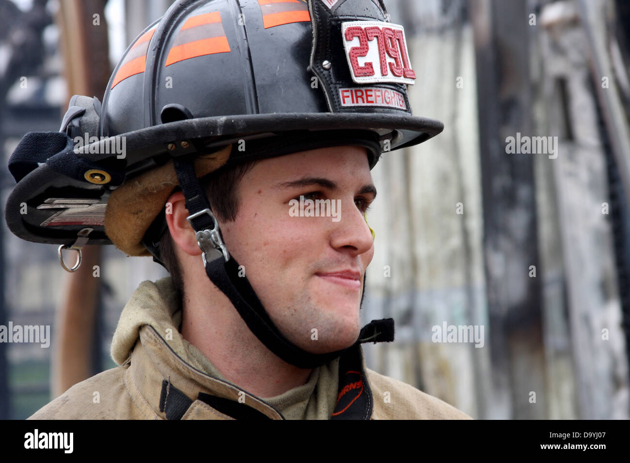 A firefighter smiling at a fire scene Stock Photo - Alamy