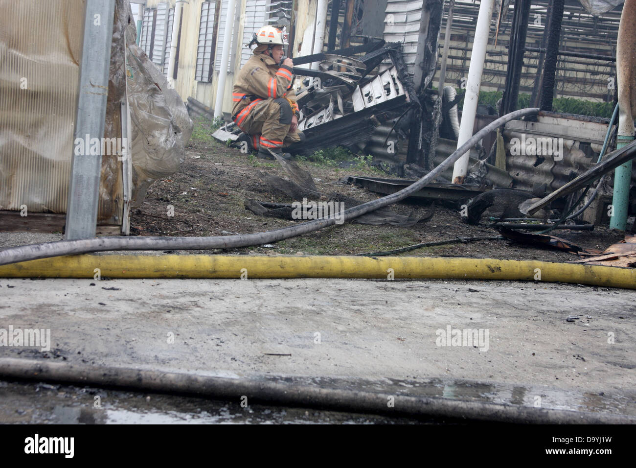 A fire chief on a radio talking to firefighters on a fire scene Stock ...