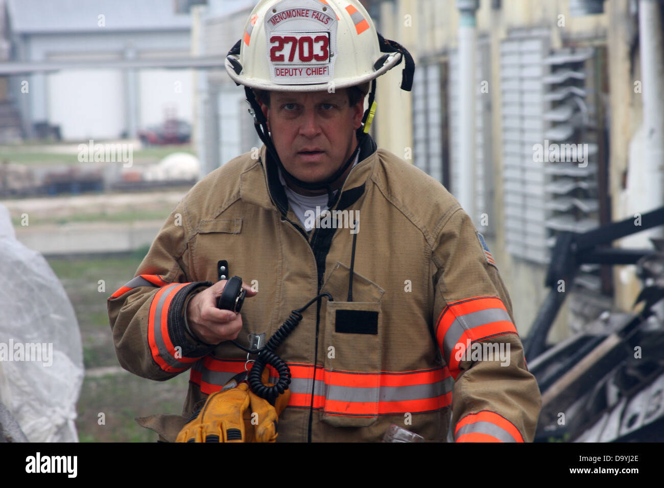 A fire chief with a radio on a fire scene Stock Photo - Alamy