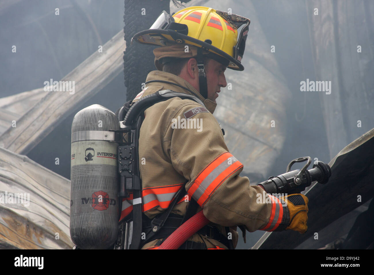 A firefighter holding a hose Stock Photo - Alamy