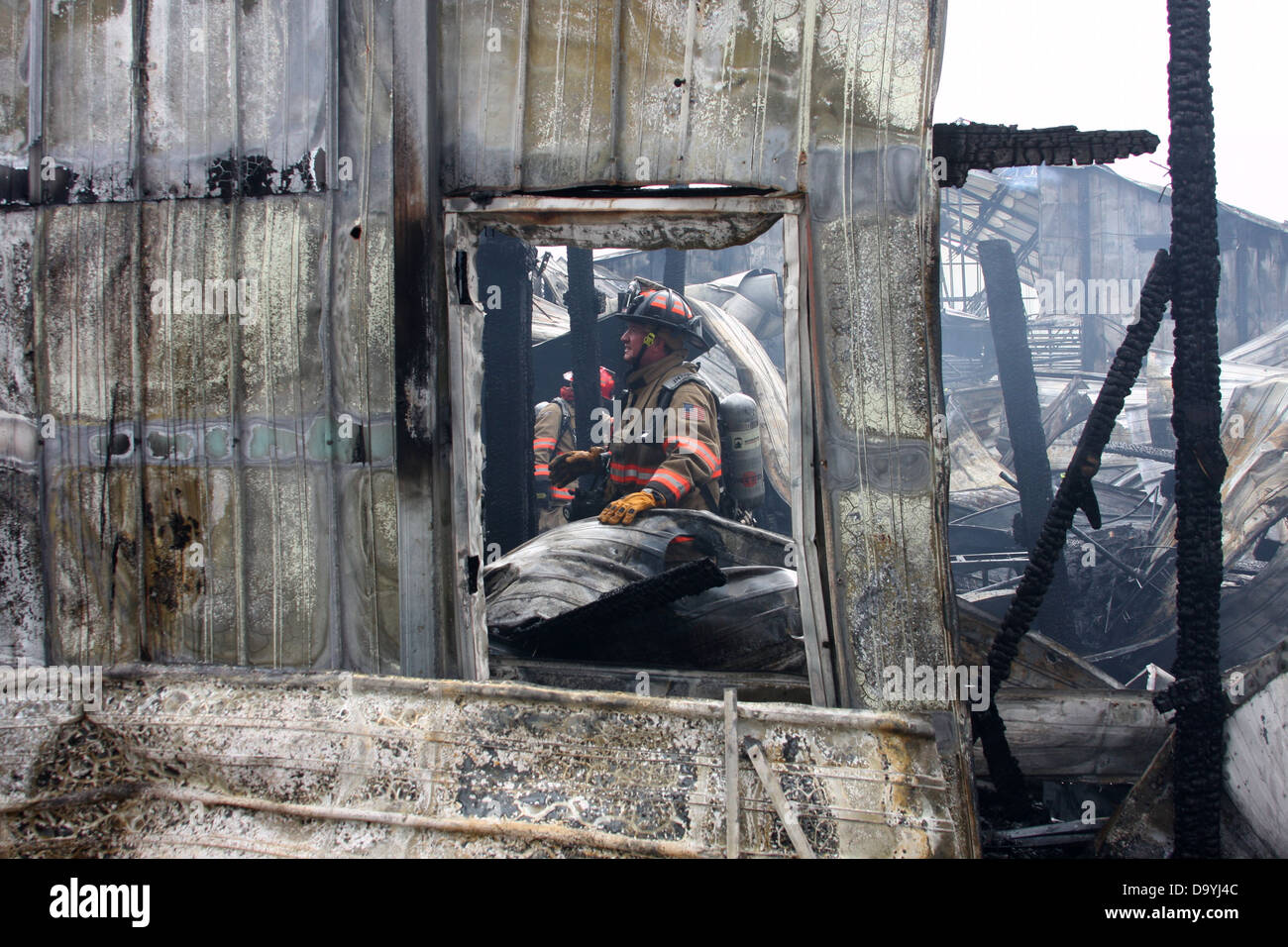 A firefigher framed by a window in a fire collapsed building Stock ...