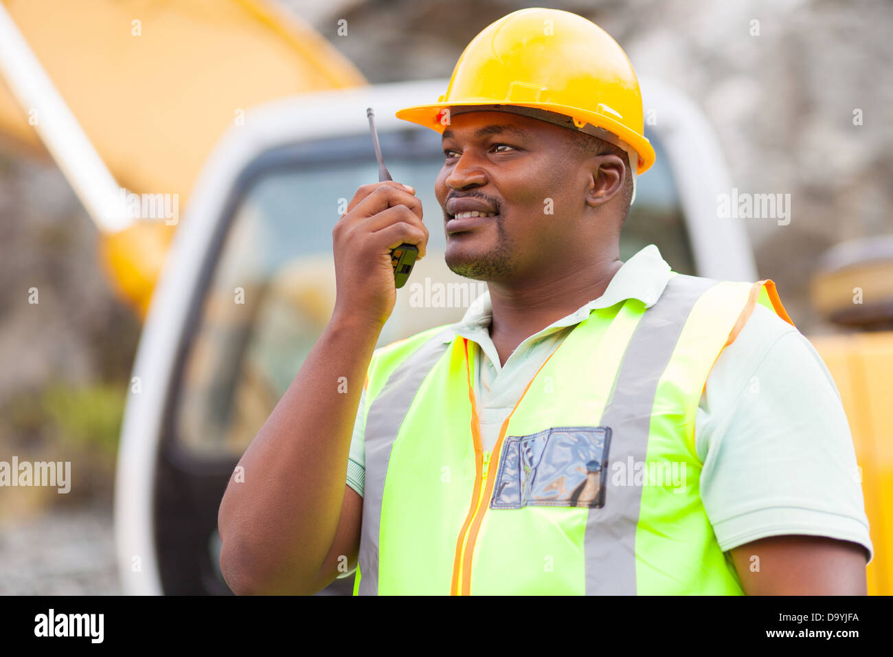 afro American industrial worker talking on walkie-talkie at mining site ...