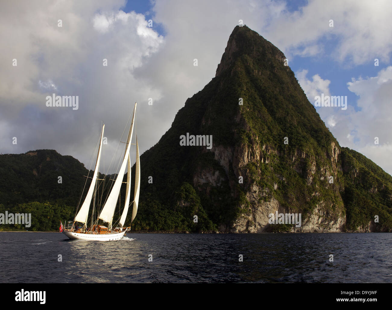 A classic yacht sails along the coast of St. Lucia with the Pitons in ...