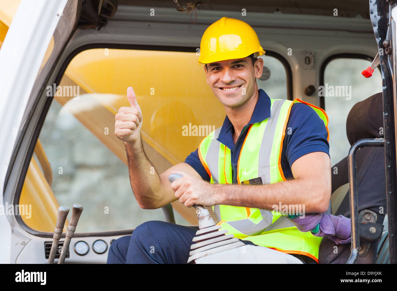 earthmover operator giving thumb up on construction site Stock Photo ...