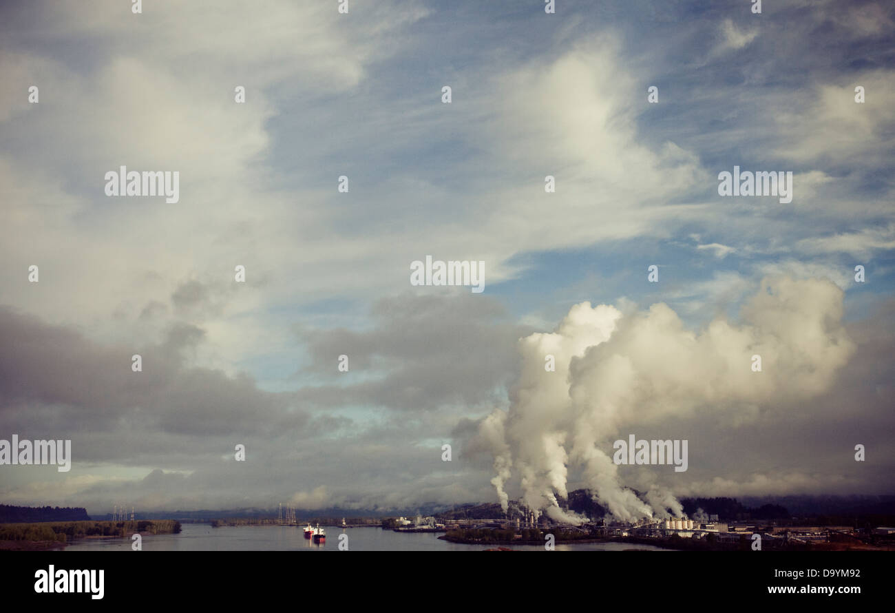 Smoke, steam, and pollution rises from an industrial plant Stock Photo ...