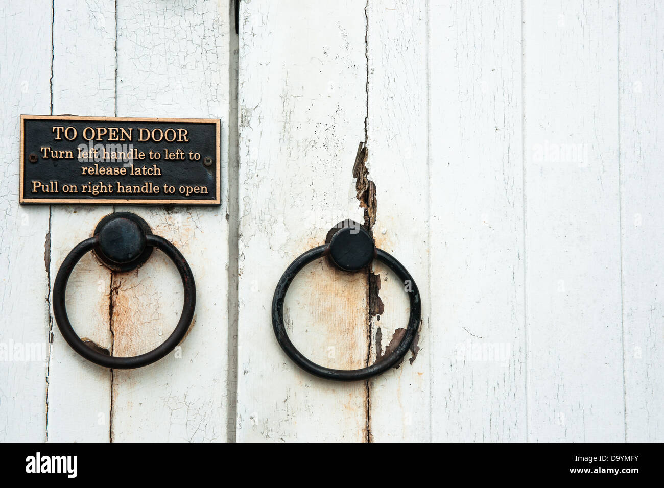 Closed door, ring handles and brass instruction sign Stock Photo - Alamy
