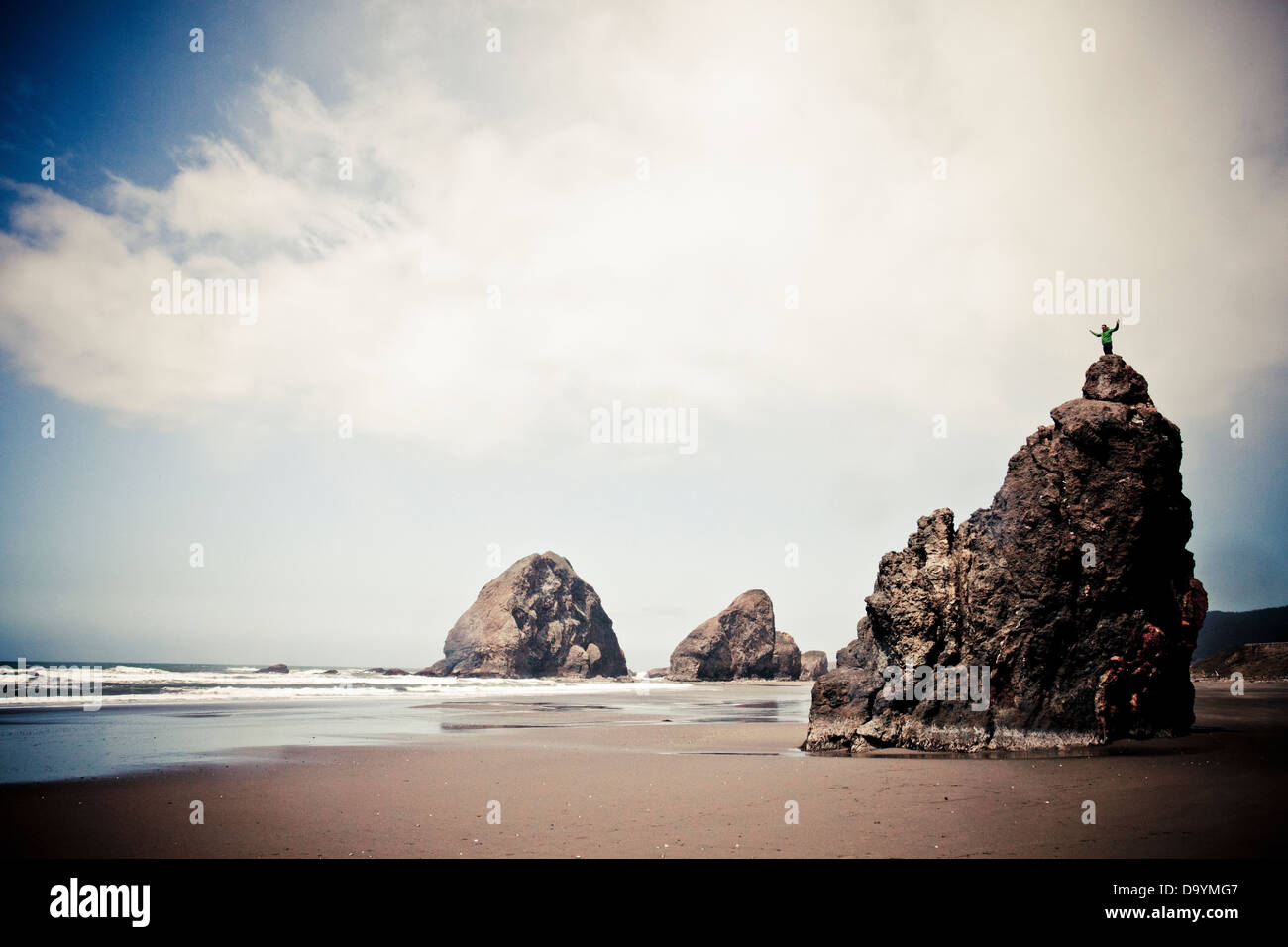 A climber stands on a monolith in Pistol River State Park on the Oregon ...