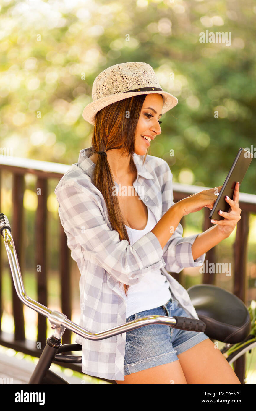 beautiful young woman reading emails on her tablet computer outdoors ...