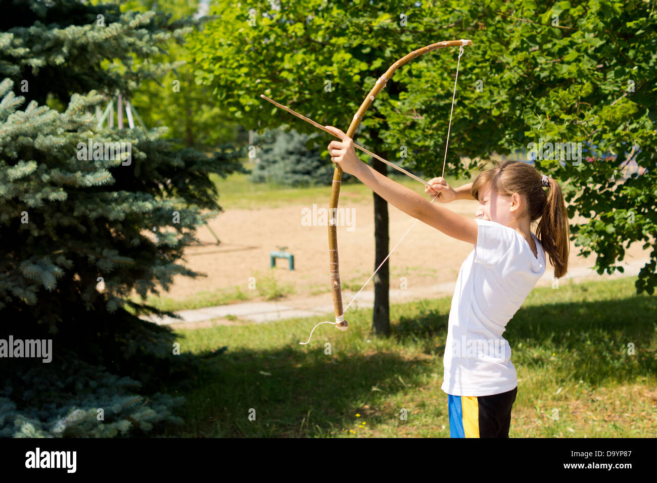 Girl practising outdoors with a arch and arrow Stock Photo - Alamy