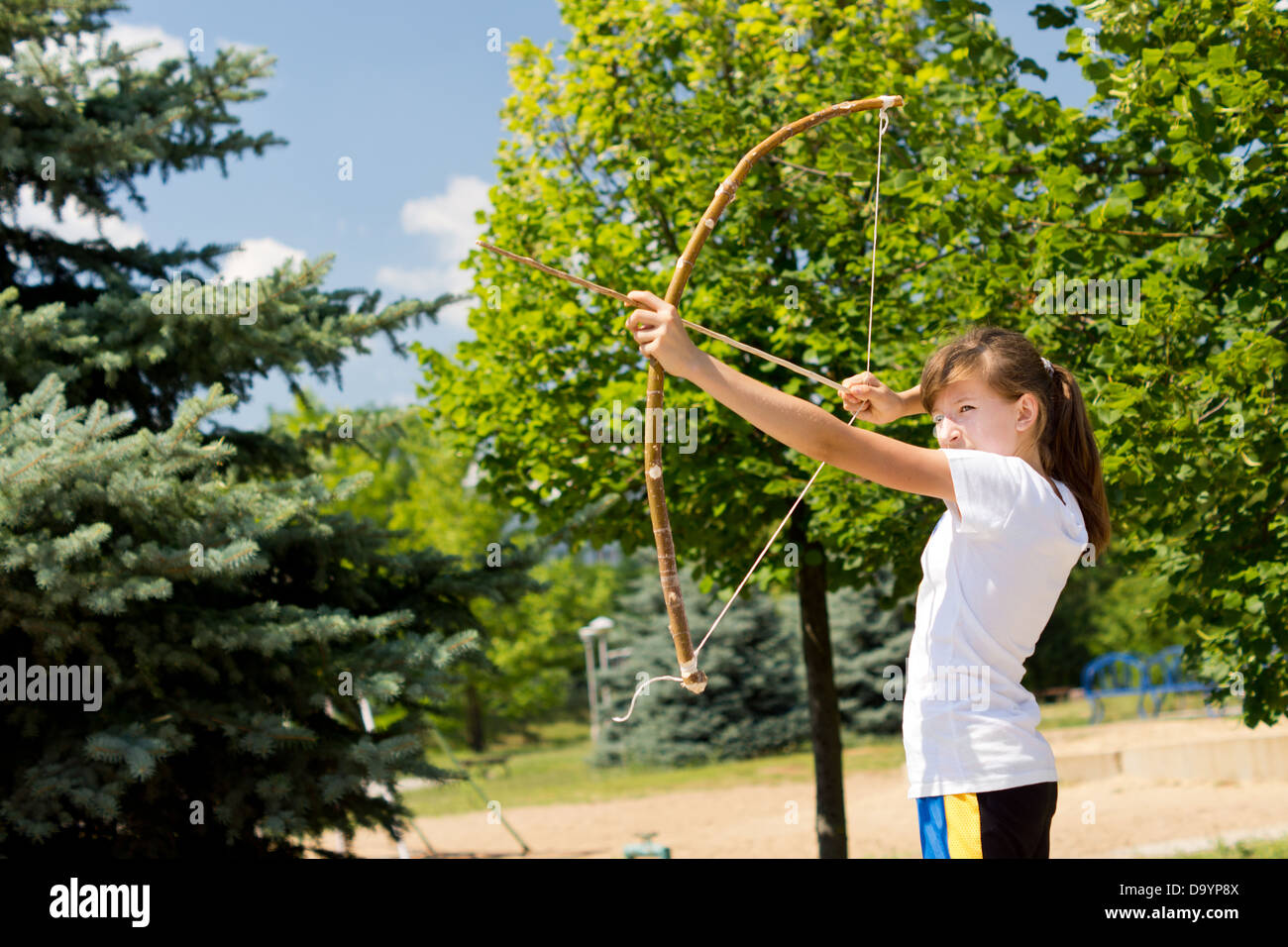Girl is taking aim with bow and arrow Stock Photo - Alamy