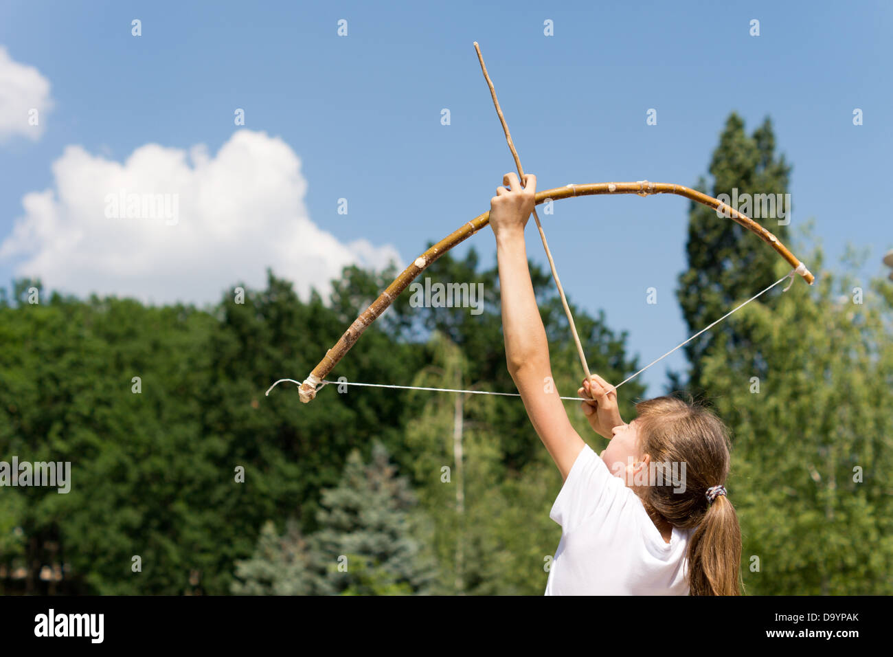 Girl is aiming her arrow at the sky Stock Photo - Alamy