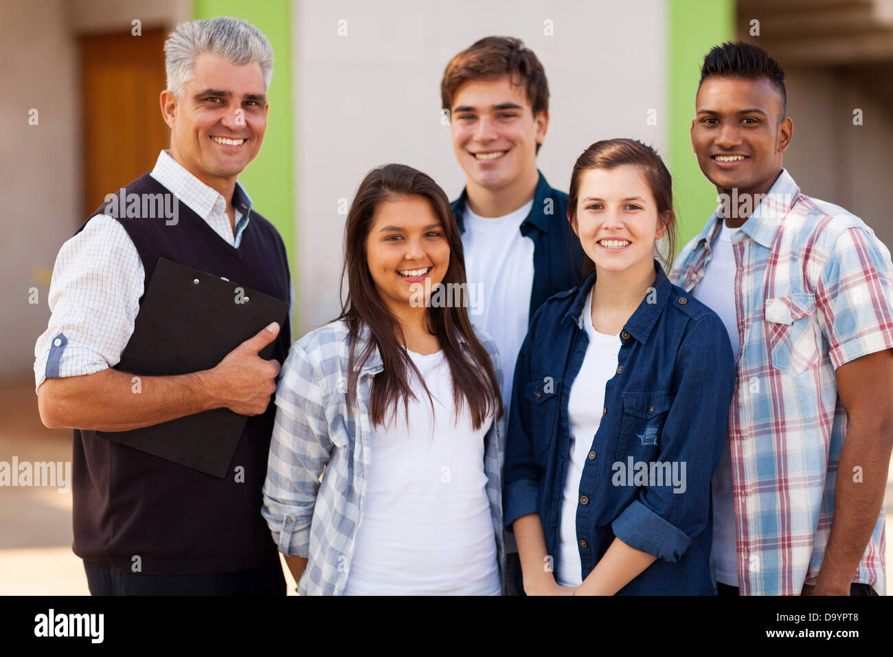 cheerful male high school teacher standing with students outdoors Stock ...