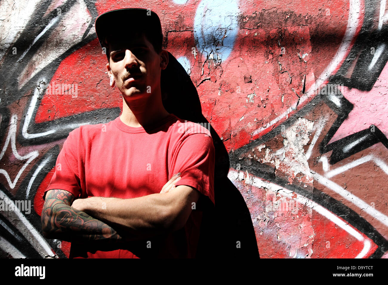 A young Rapper leaning against a wall Stock Photo - Alamy