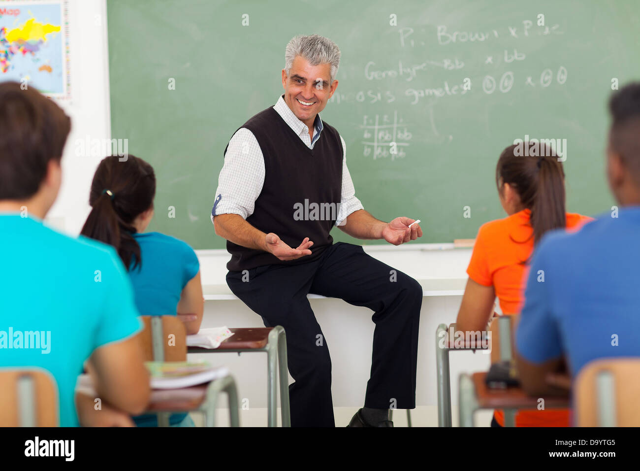 friendly male teacher explaining lesson to students in classroom Stock ...