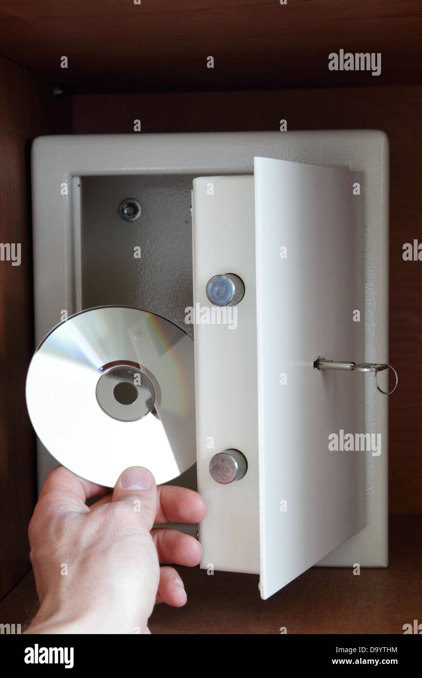 Man putting a CD into a safe Stock Photo - Alamy