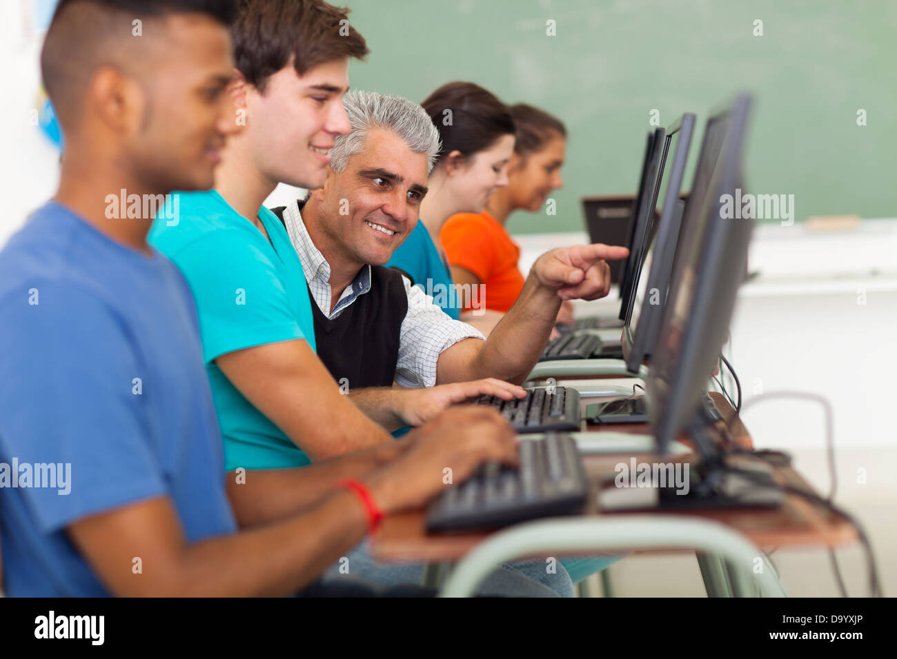 happy male senior teacher helping student with computer Stock Photo - Alamy