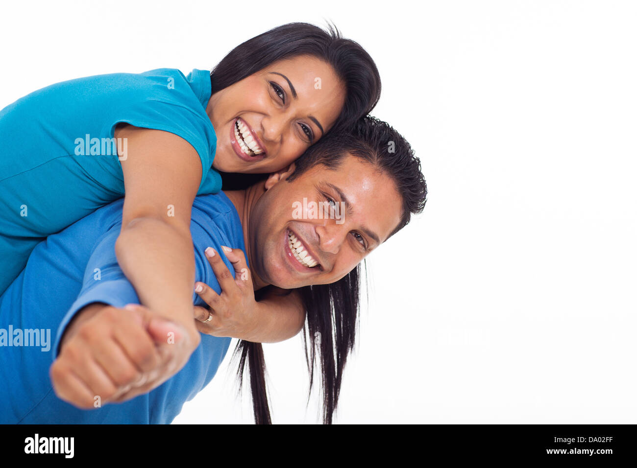 happy young indian couple having fun with piggyback on white background ...