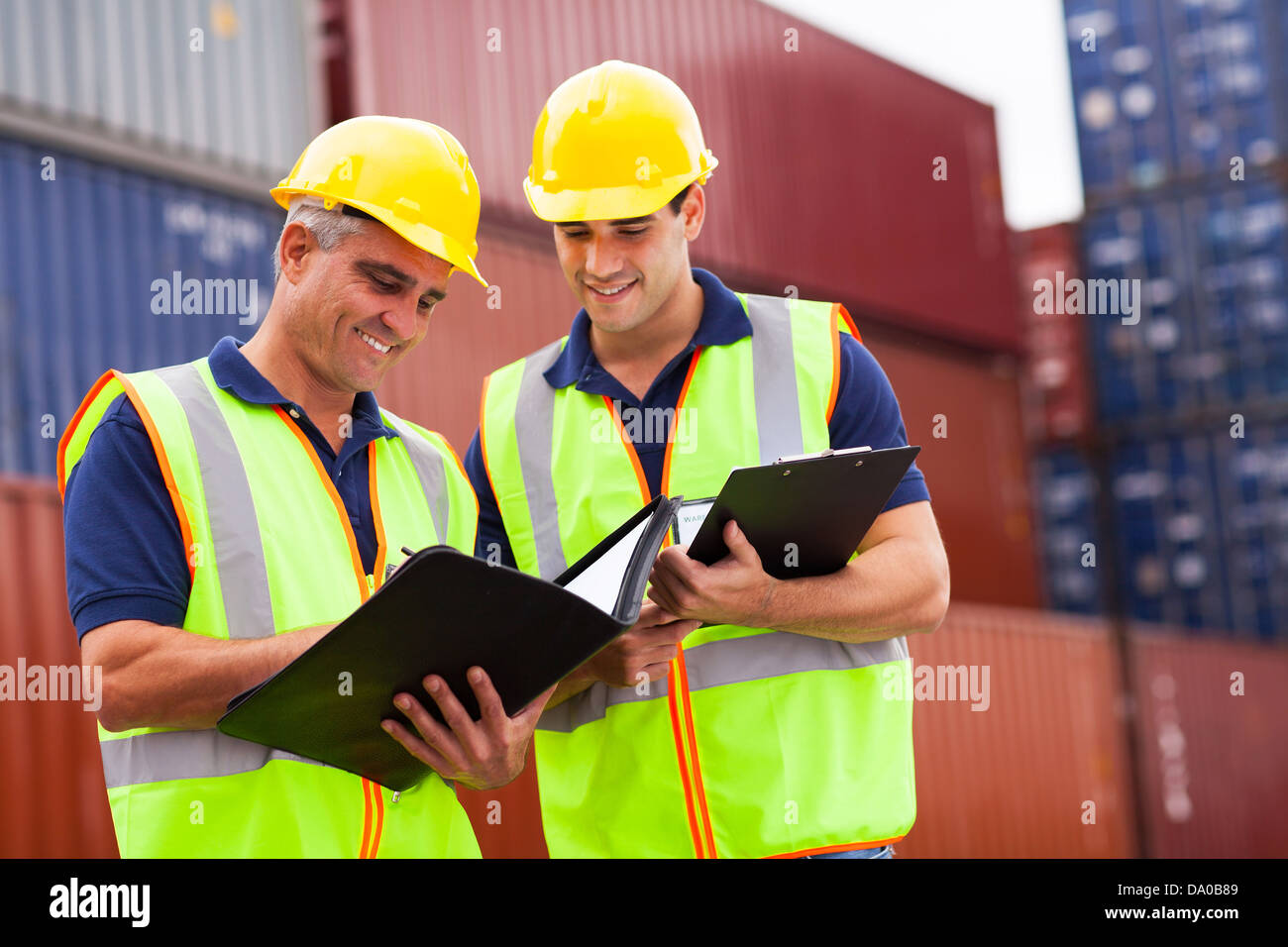 two harbor workers working at container yard Stock Photo - Alamy