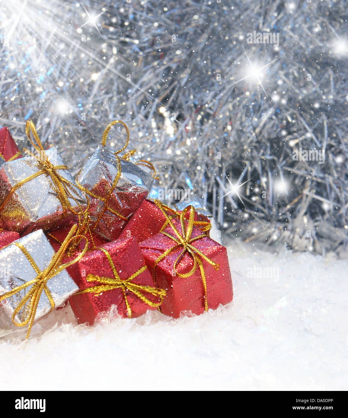Christmas gifts in snow on a sparkly silver background Stock Photo - Alamy