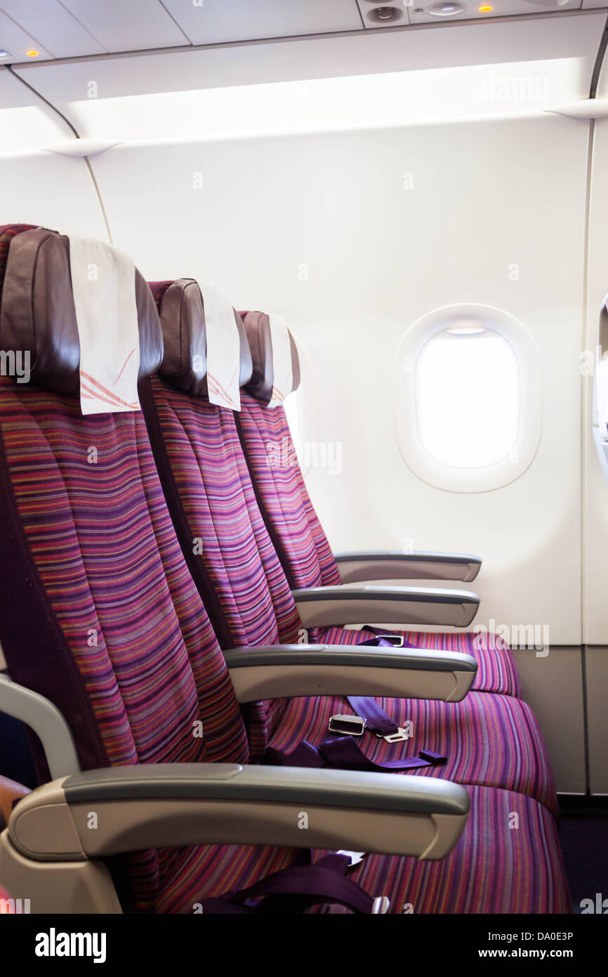 Airplane seat row in passenger cabin with window beside Stock Photo - Alamy