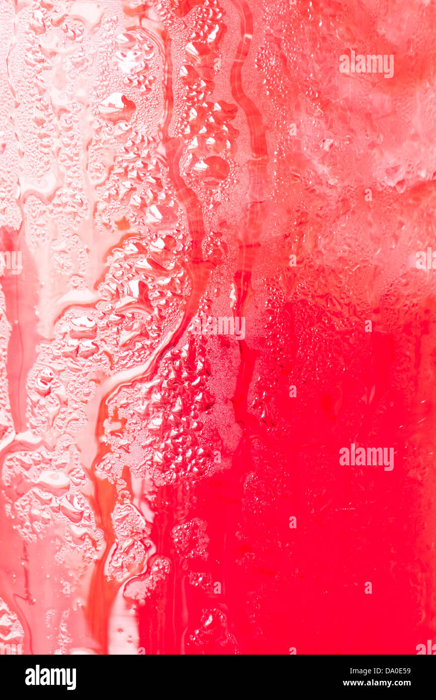 Glass surface of red water with ice cubes background Stock Photo - Alamy