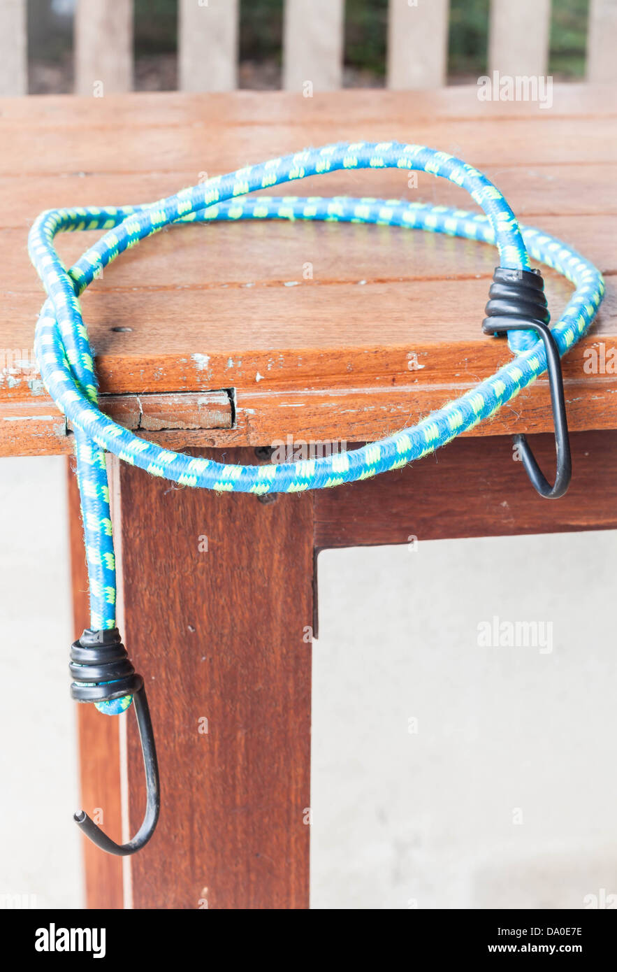 Black hooks of blue rubber band on wood table Stock Photo - Alamy