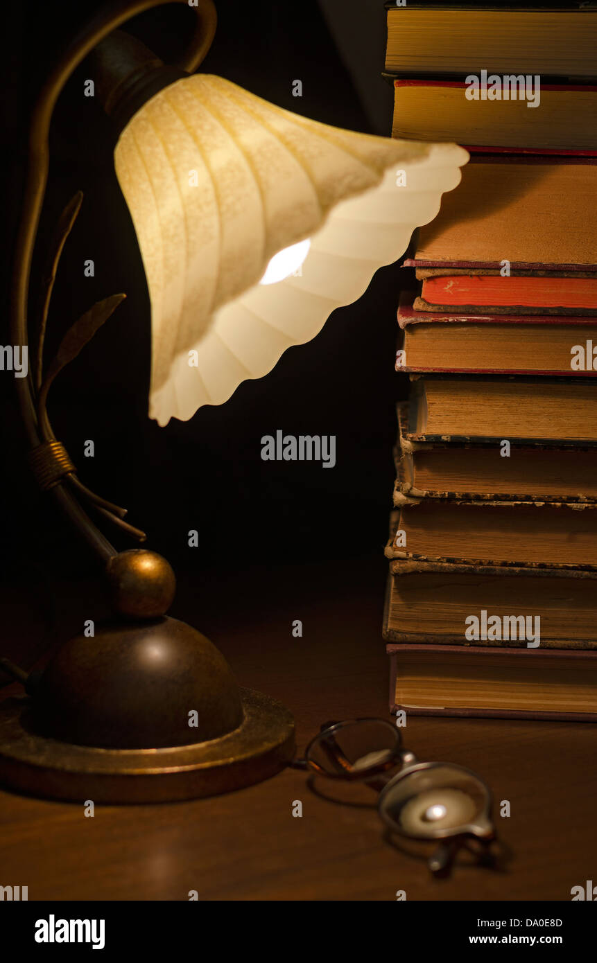 Antique books, reading lamp and glasses Stock Photo - Alamy