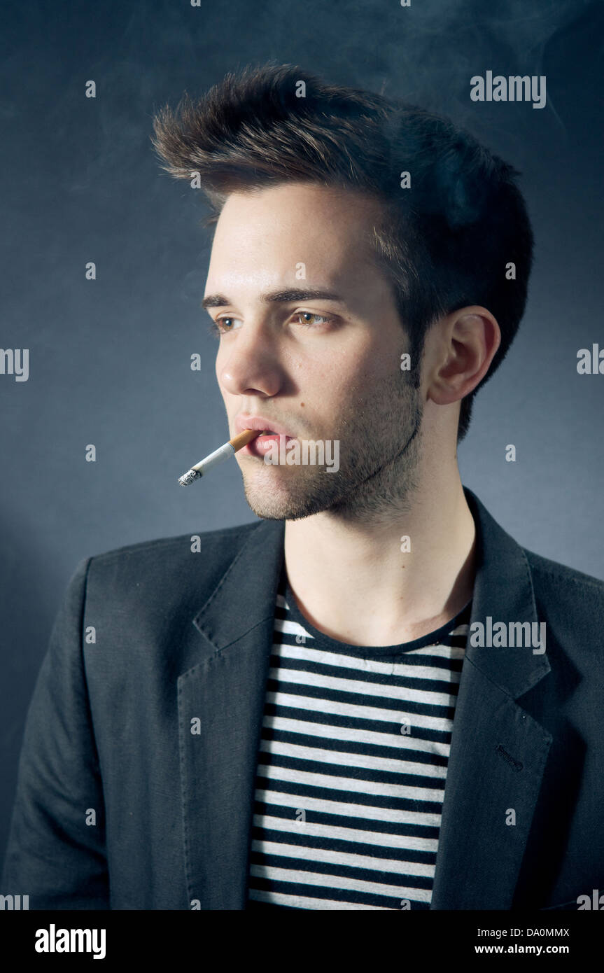 Young man smoking cigarette Stock Photo - Alamy
