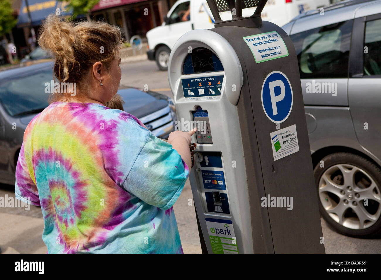 A woman operates an electronic parking machine Stock Photo - Alamy