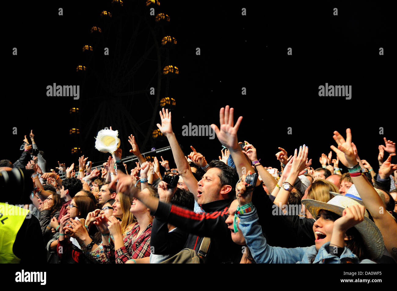 BARCELONA - MAY 23: Fans watching a concert with a ferris wheel behind ...