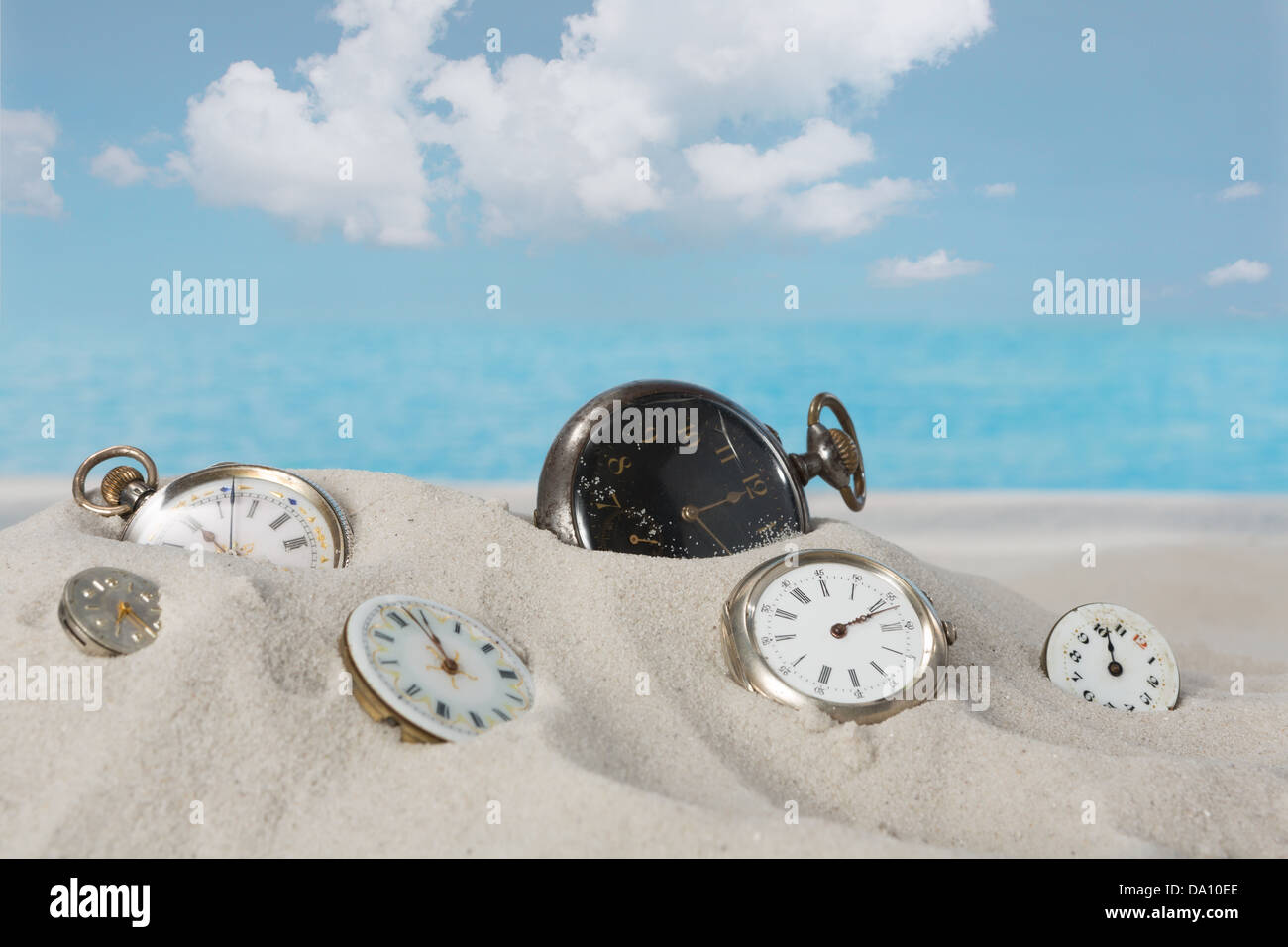 Several antique pocket watches and clocks lying in the beach sand Stock ...