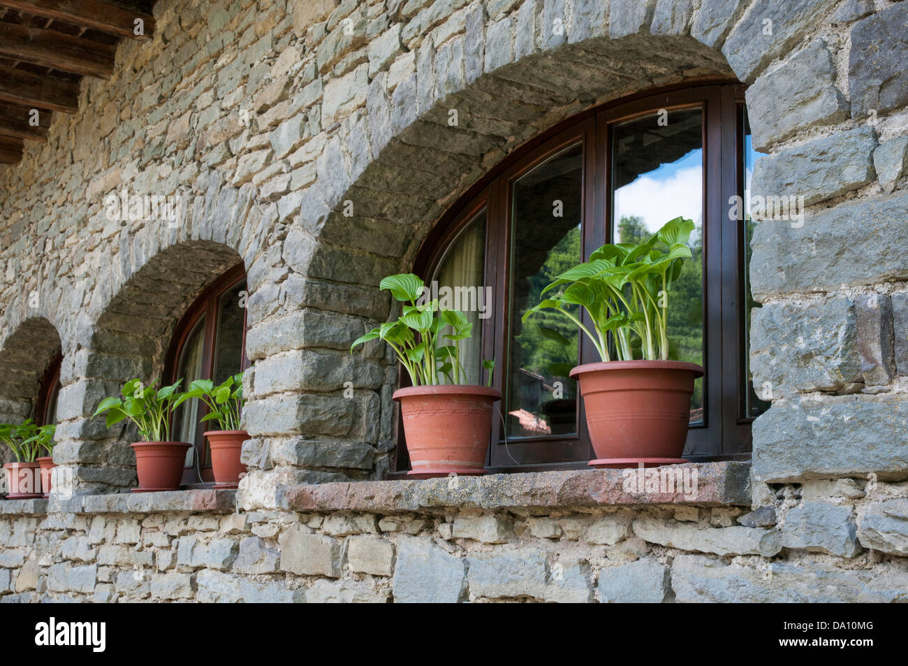 stone old windows with flowers Stock Photo - Alamy