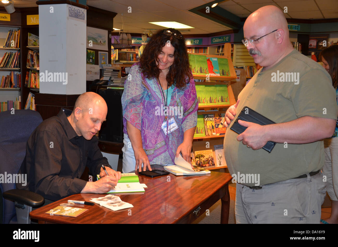 Jim Ottaviani autographs a book at book signing for his new book ...