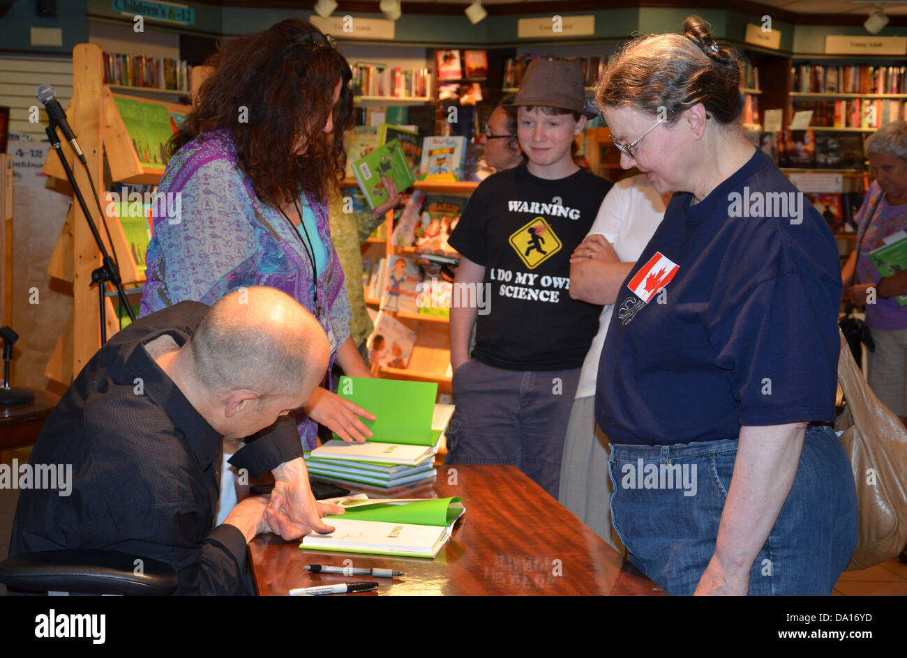 Jim Ottaviani thumbprints a book at book signing for his new book ...