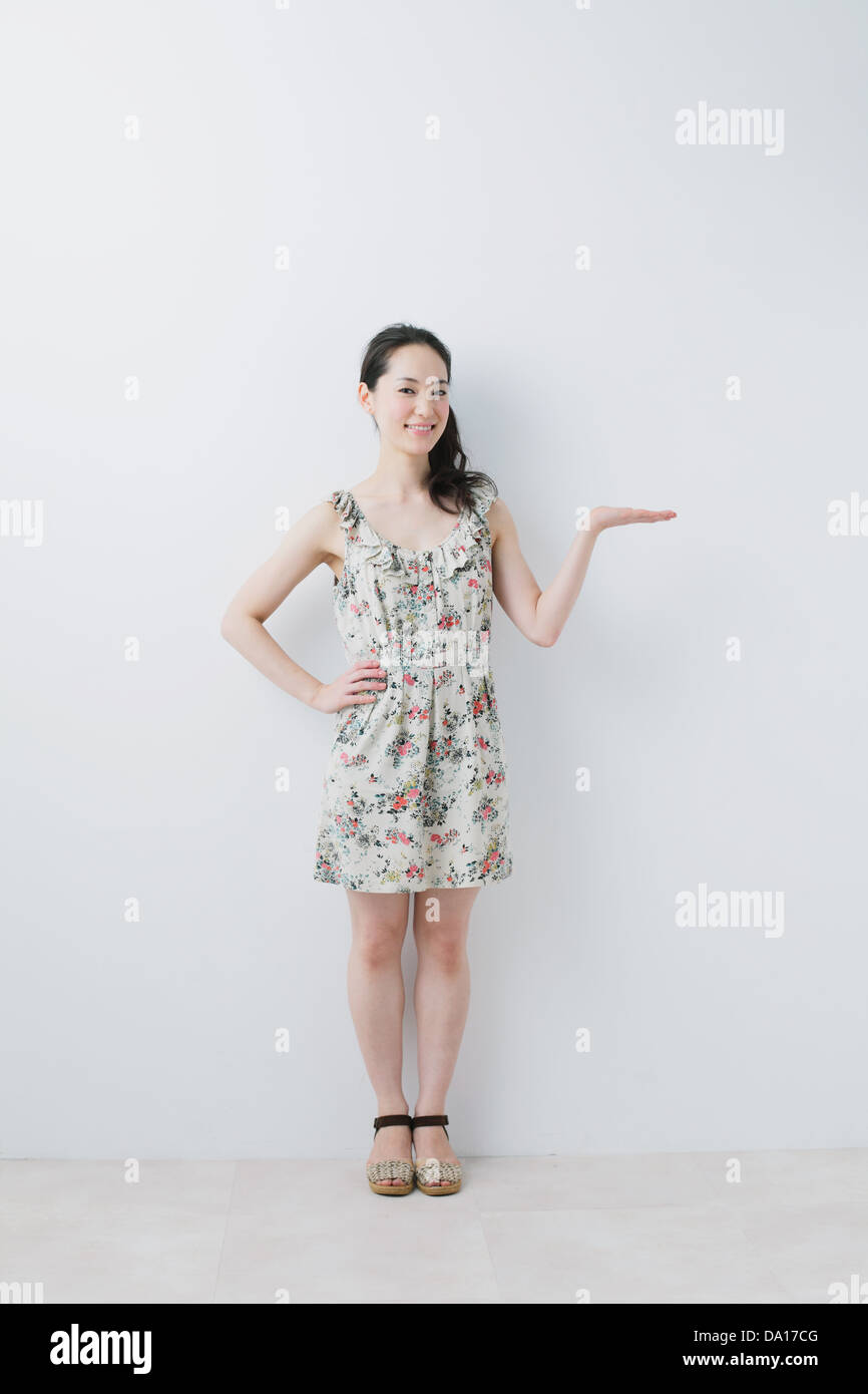 Young woman wearing one piece with raised arm Stock Photo - Alamy