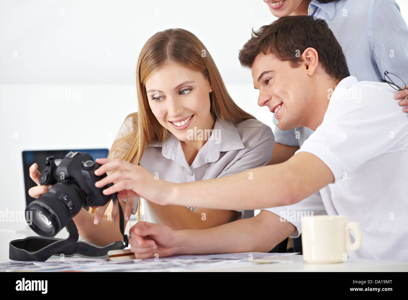 Participants of a photo workshop looking at camera display Stock Photo ...