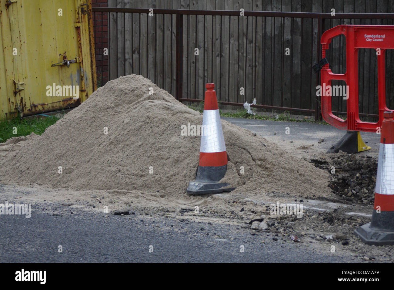 Construction materials at side of road, image shows 2 traffic cones ...
