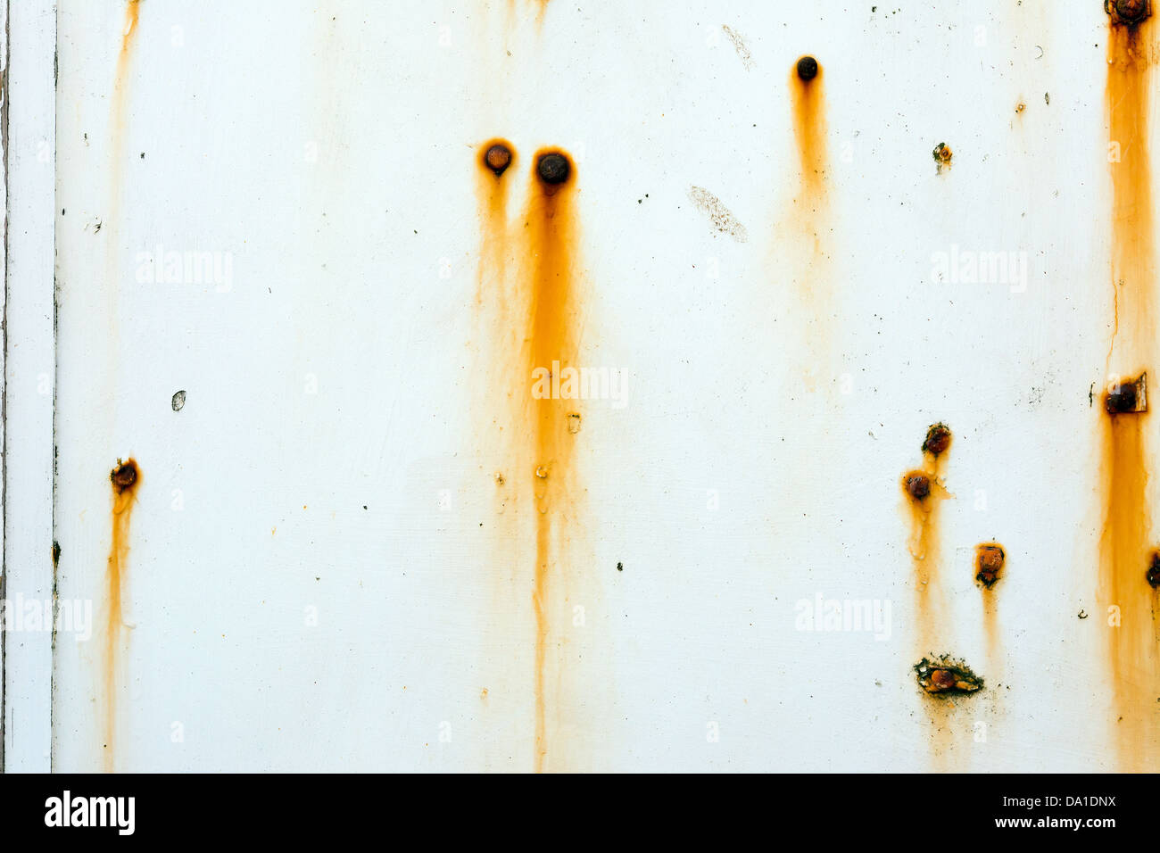 White painted wall with rusting screws showing through Stock Photo - Alamy